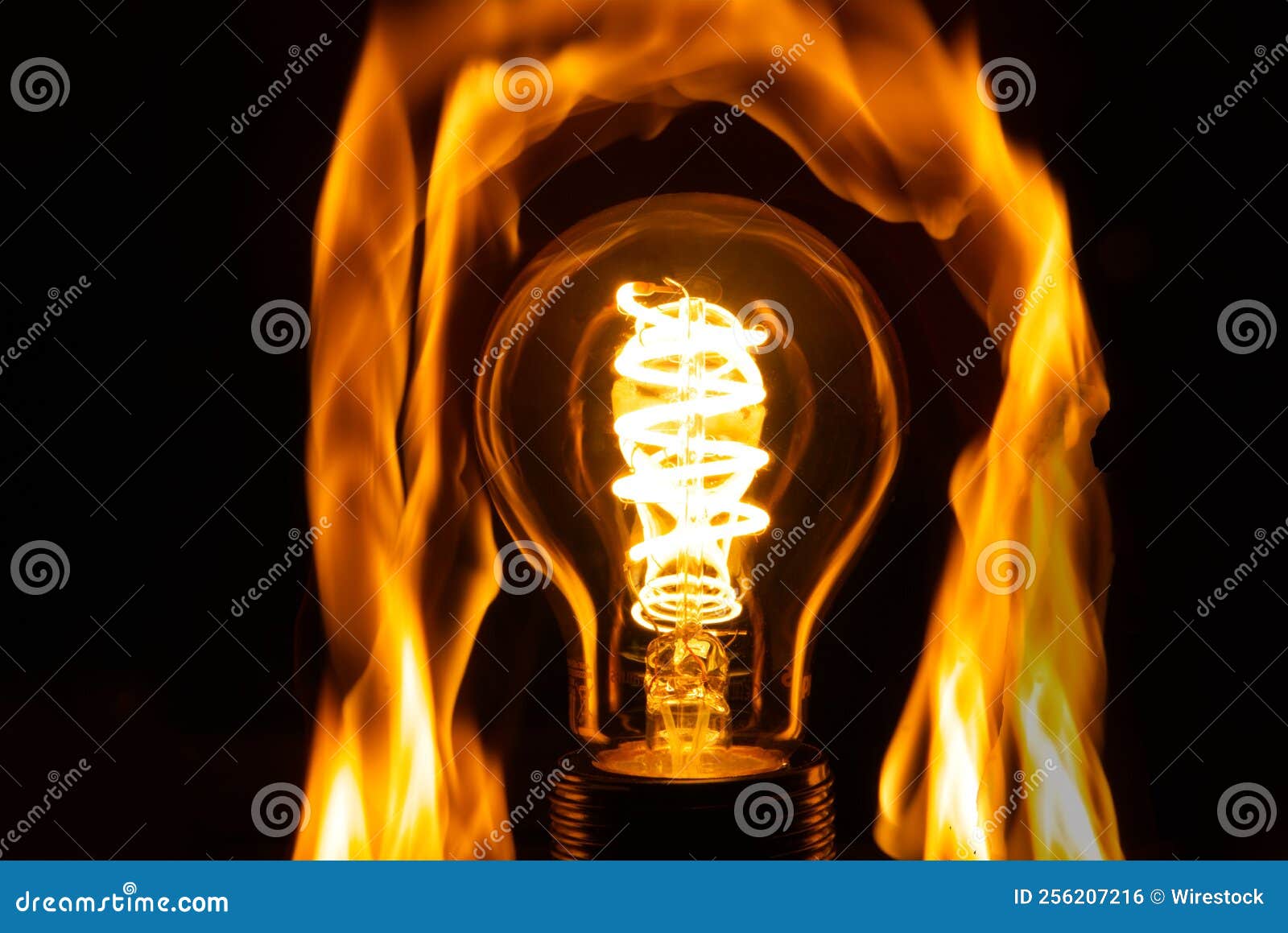 Light Bulb with Fire Flames Around it on a Black Background Stock Photo ...