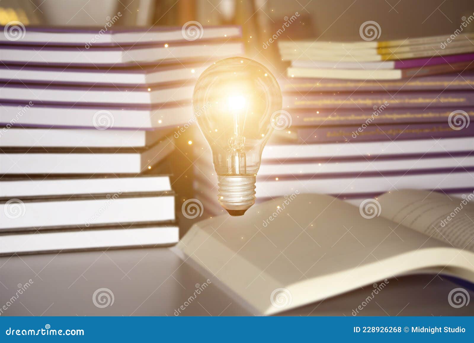 A Light Bulb that Illuminates a Table with Stacks of Books. Stock Photo ...