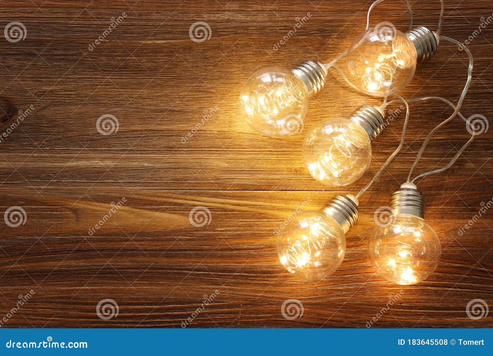 Light Bulb Lamps with Warm Light Over Old Wooden Background Stock Photo ...
