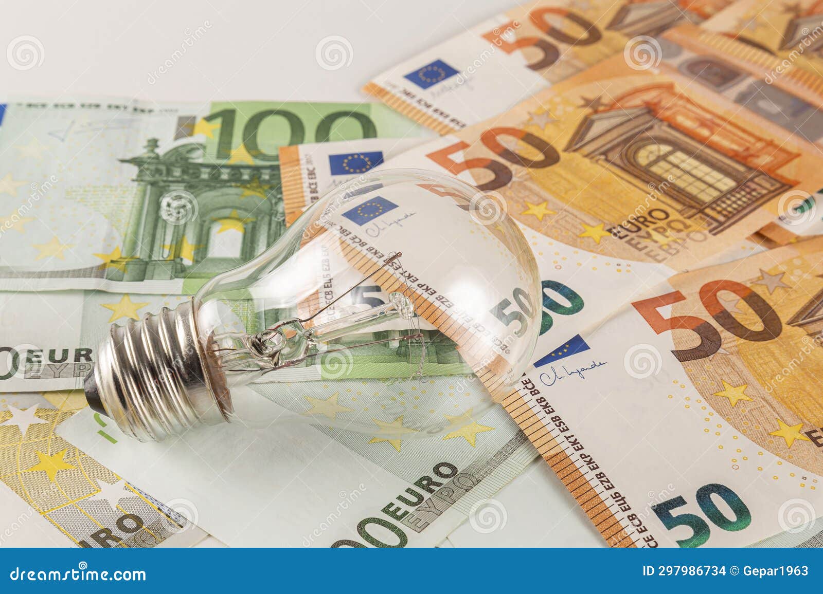 A Light Bulb Lies on a Table Covered with Large Quantity of Euro ...