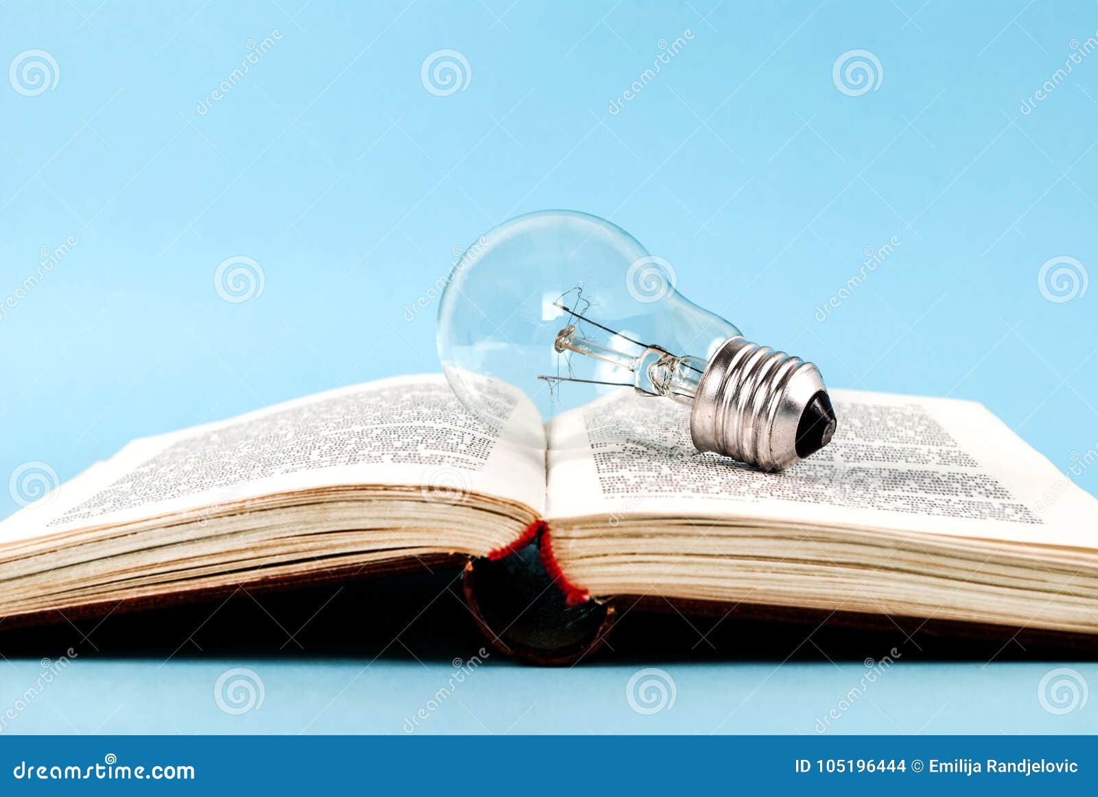 Light Bulb on Open Book Isolated on a Blue Background Stock Photo ...