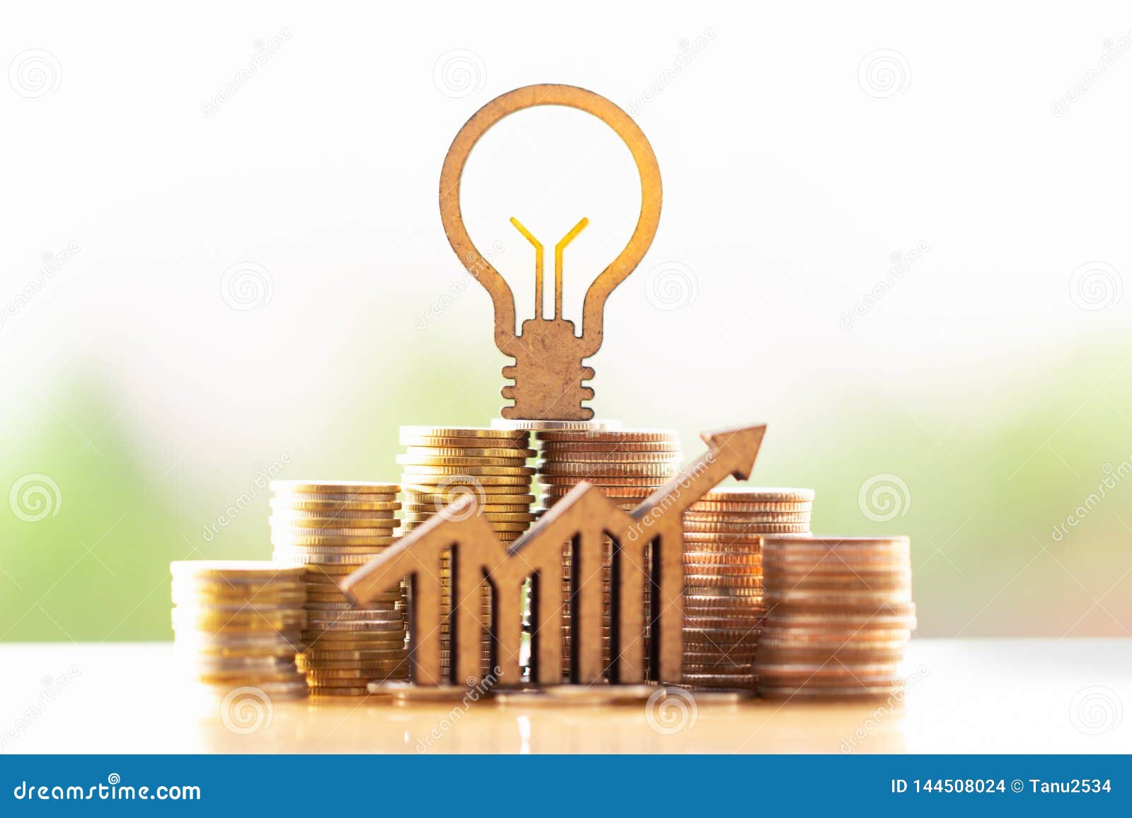 Light Bulb and Stack of Coins in Concept of Savings and Money Growing ...