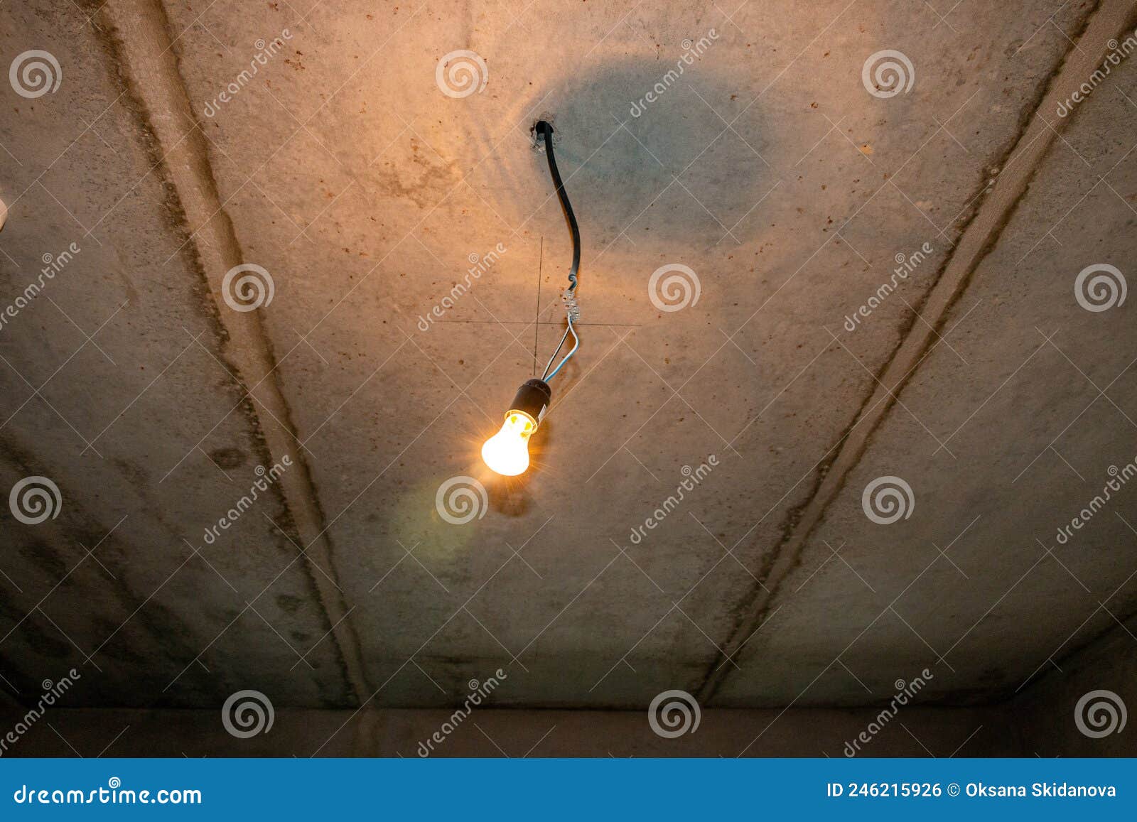 A Light Bulb with Wires, on Unprocessed Concrete Coating, in Process of ...