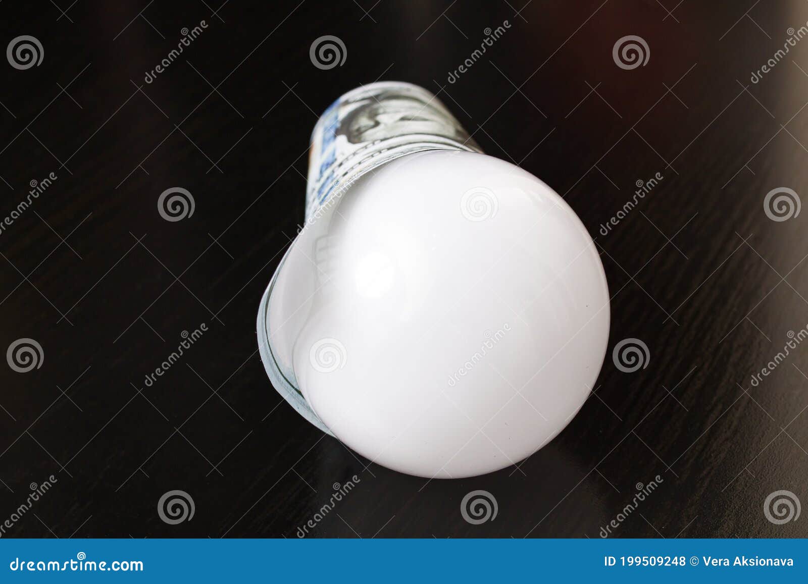 Light Bulb Wrapped in Dollars on Wooden Table Stock Photo - Image of ...