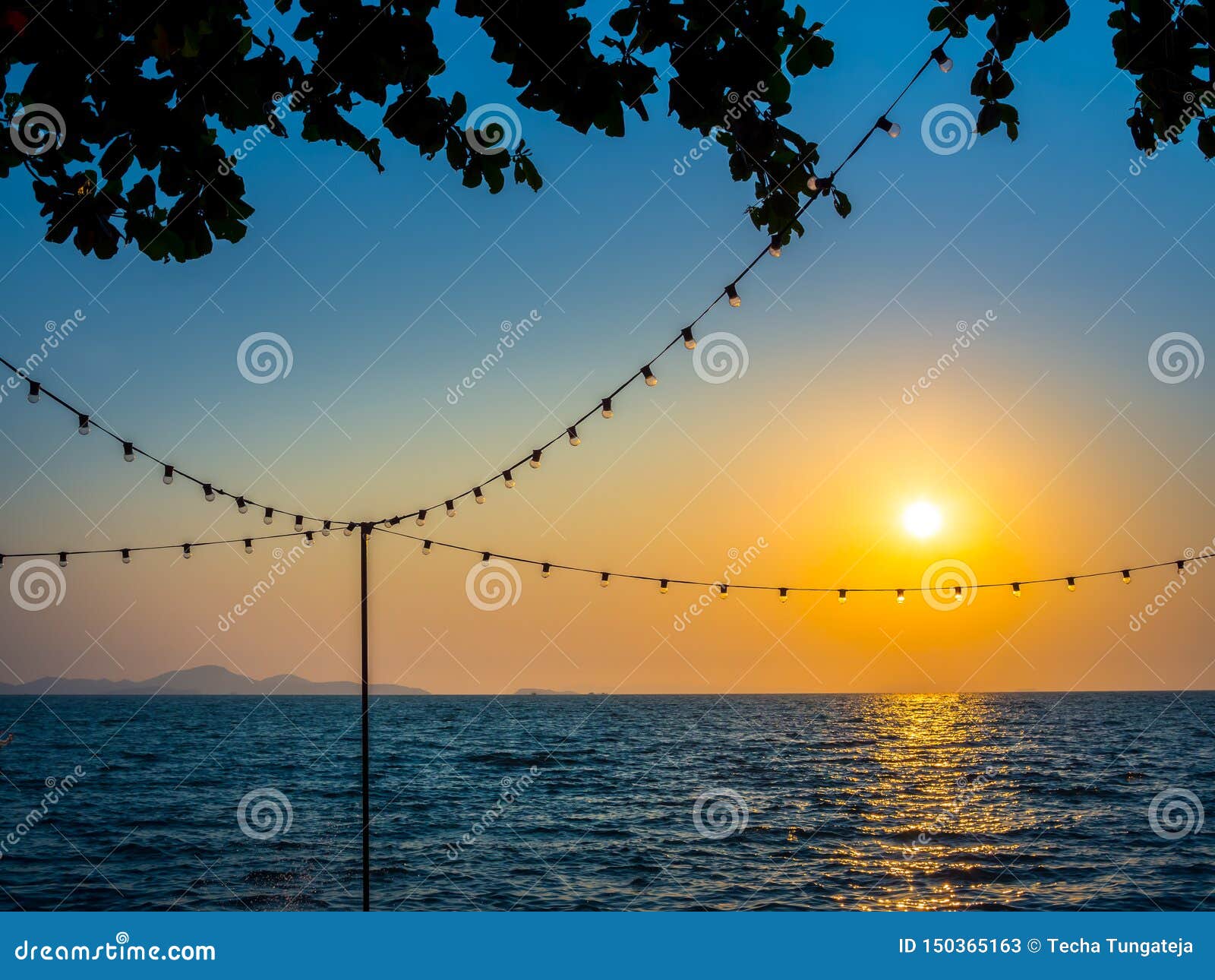 Light Bulbs Hanging on String Wire and.the Sun on Sunset Sky Stock ...