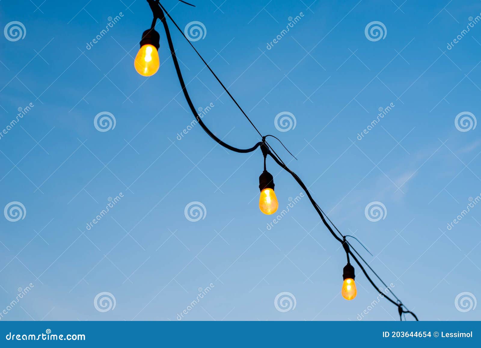 Light Bulbs on String Wire Against Sunset Sky by the Sea Stock Photo ...