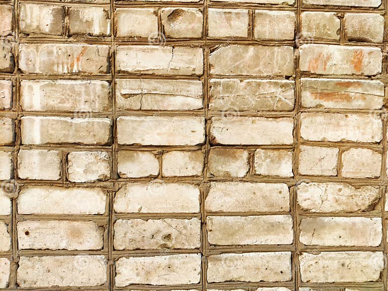 A Light-colored Brick Wall Displays Unique Textures and Patterns ...