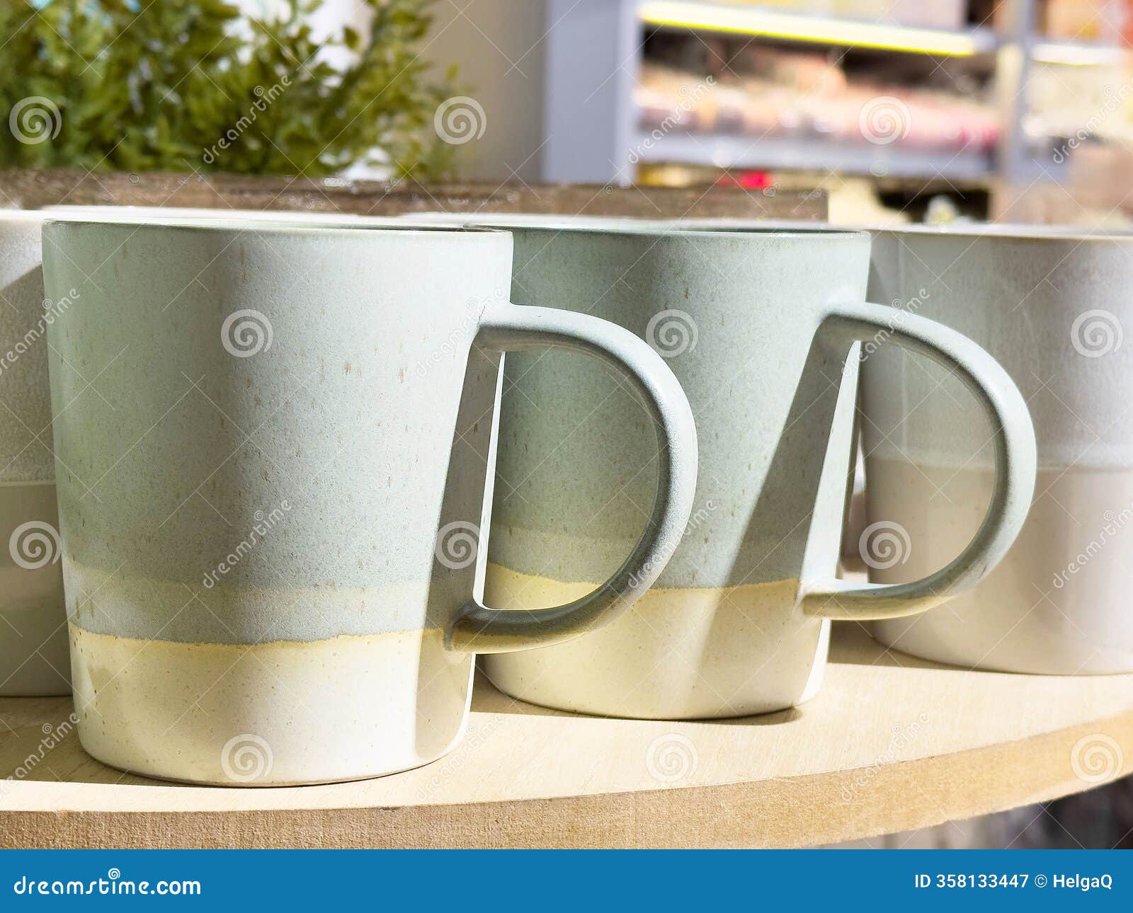 Light Green and White Ceramic Mugs on Wooden Shelf in Store Display ...
