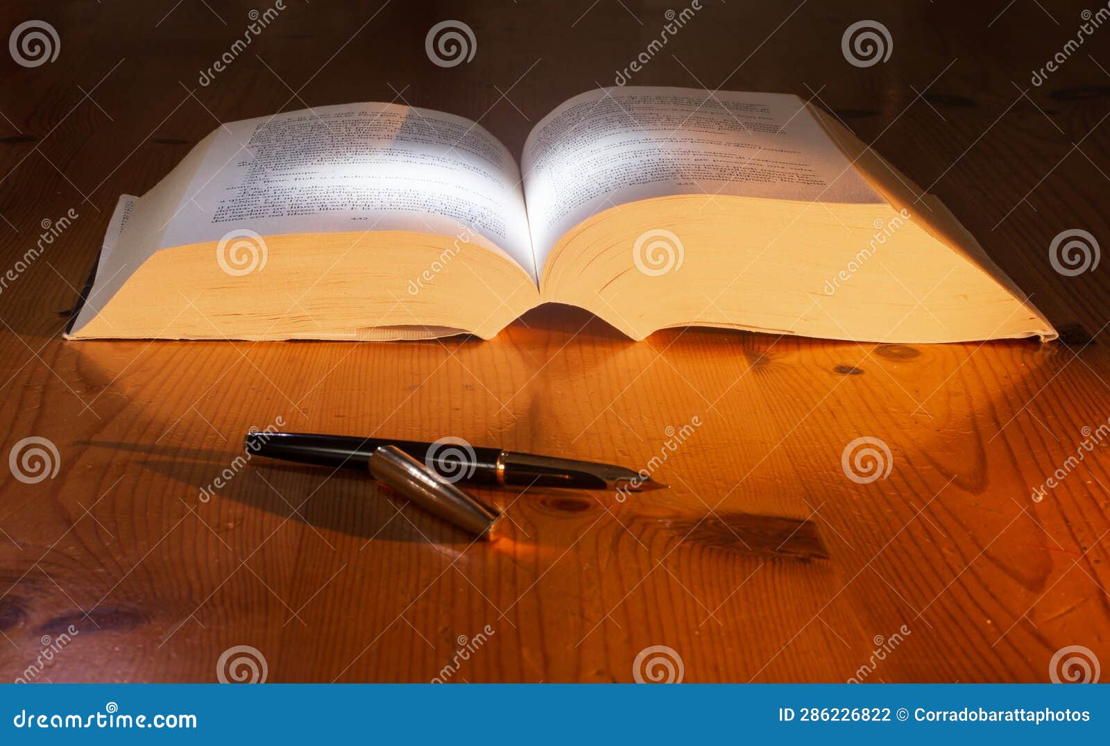 The Light Illuminates an Open Book and a Pen Stock Photo - Image of ...