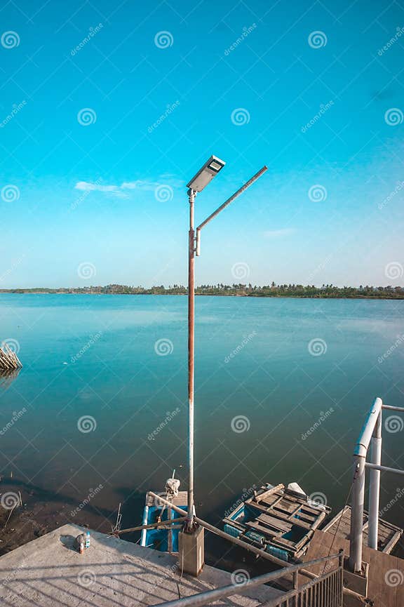 A Light Pole on the Edge of the Pier with a Backdrop of the Sea and ...