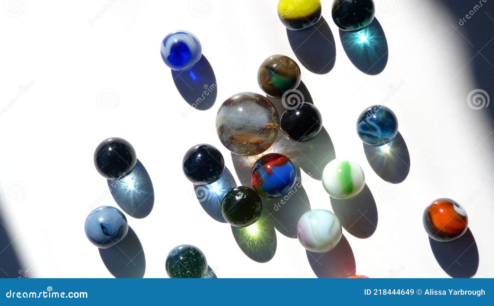 Light Reflecting through Colorful Glass Marbles on a White Surface ...