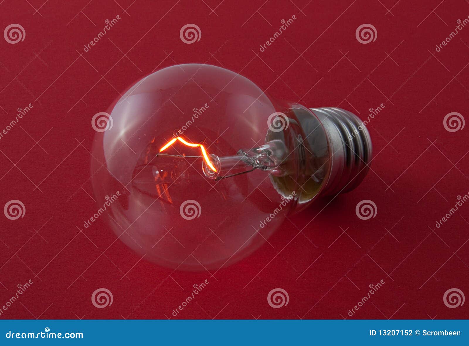 Lightbulb on a red surface stock photo. Image of watt - 13207152