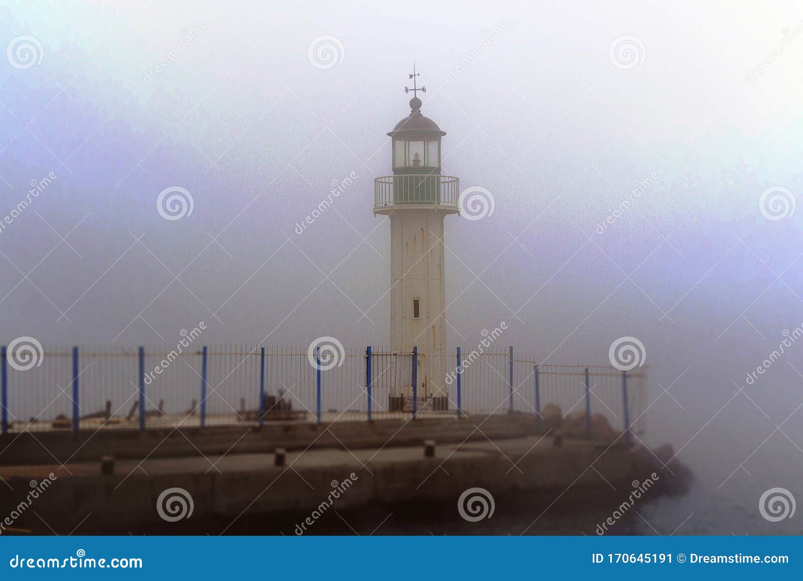 Lighthouse in autumn fog stock image. Image of surrounded - 170645191