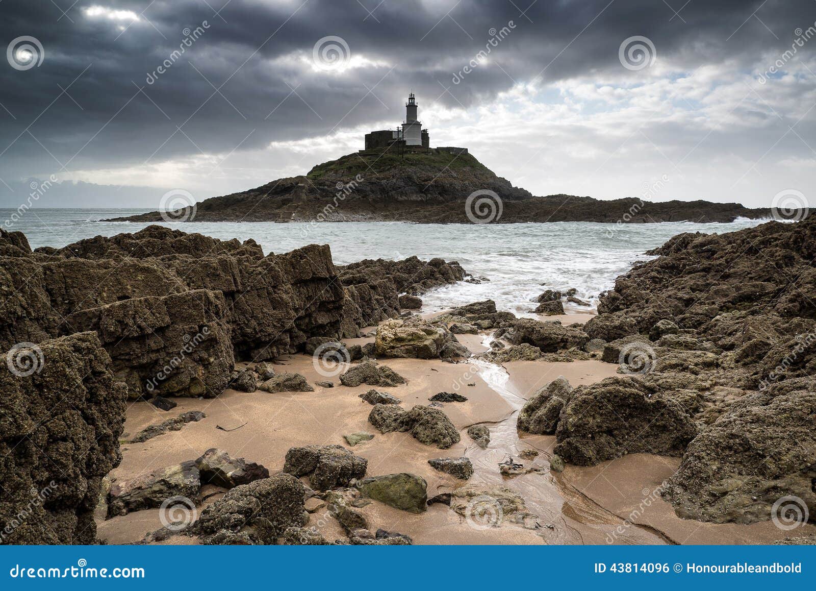 Lighthouse Landscape with Stormy Sky Over Sea with Rocks in Fore Stock ...