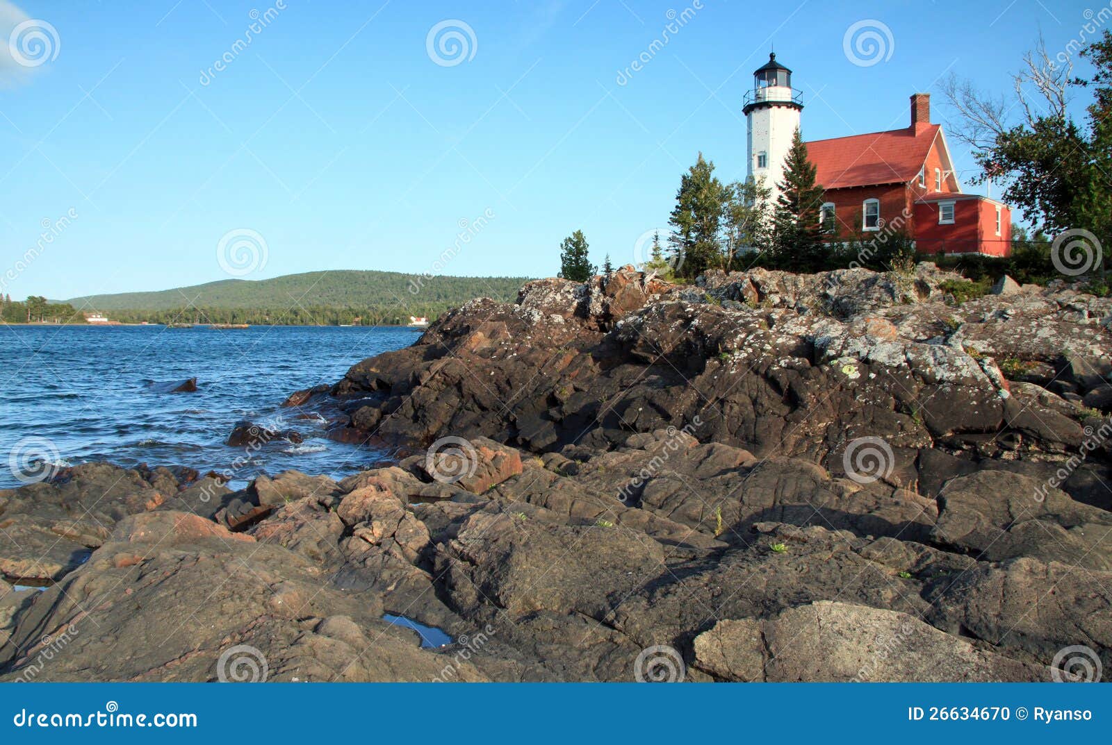 Lighthouse Overlooking Harbor Stock Photo - Image of scenic, beach ...