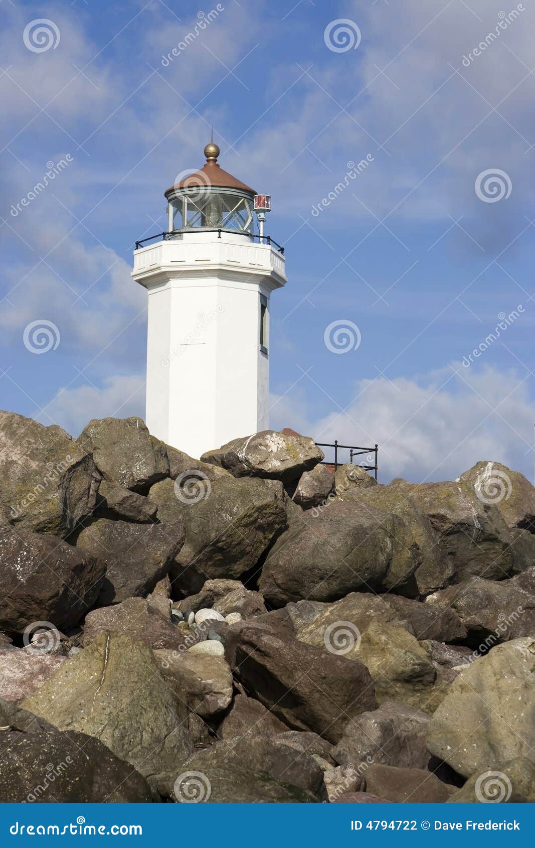 Lighthouse Peaks Above Rocks Stock Photo - Image of light, lighthouse ...