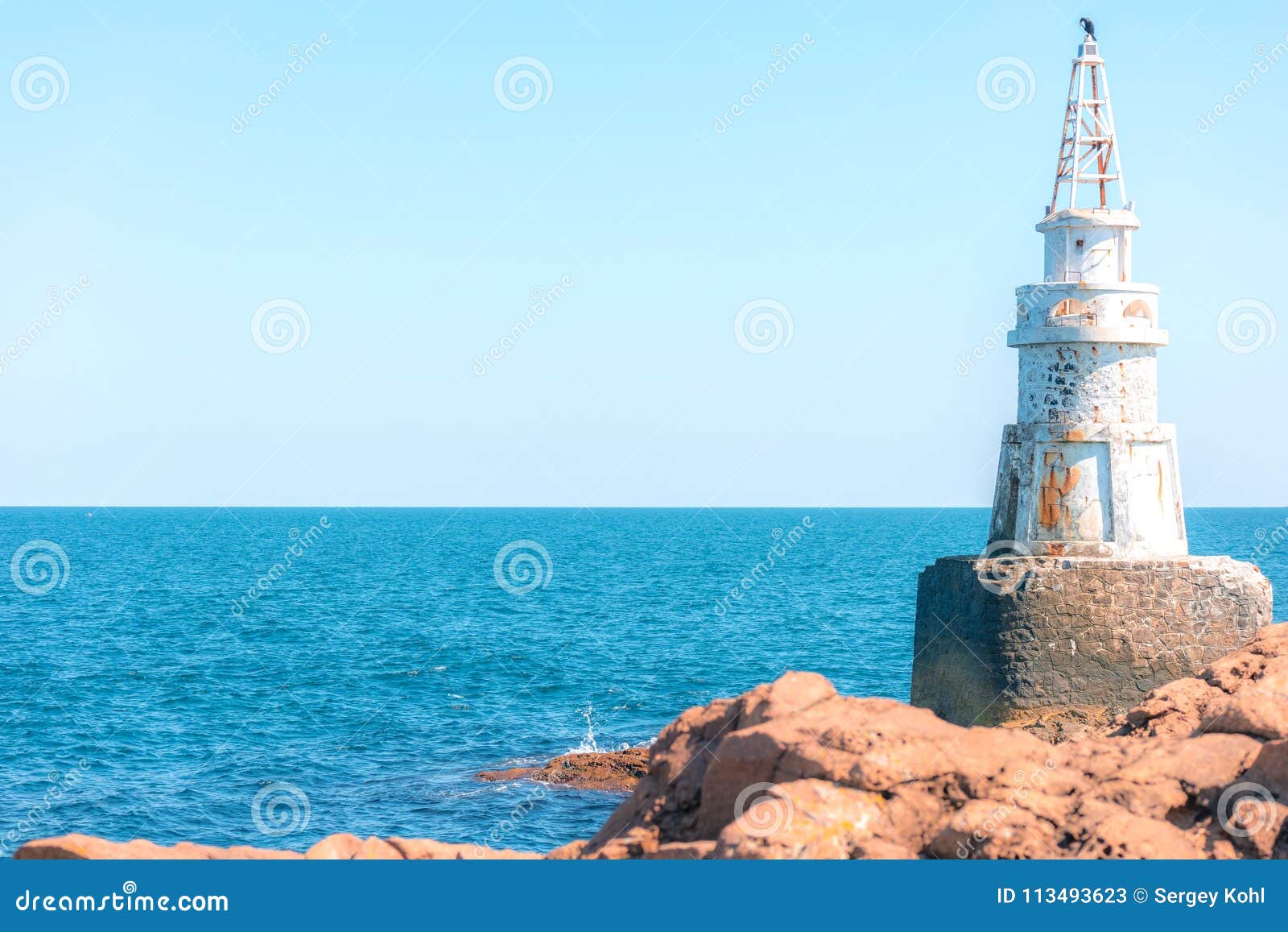 A lighthouse on the rocks. stock image. Image of blue - 113493623