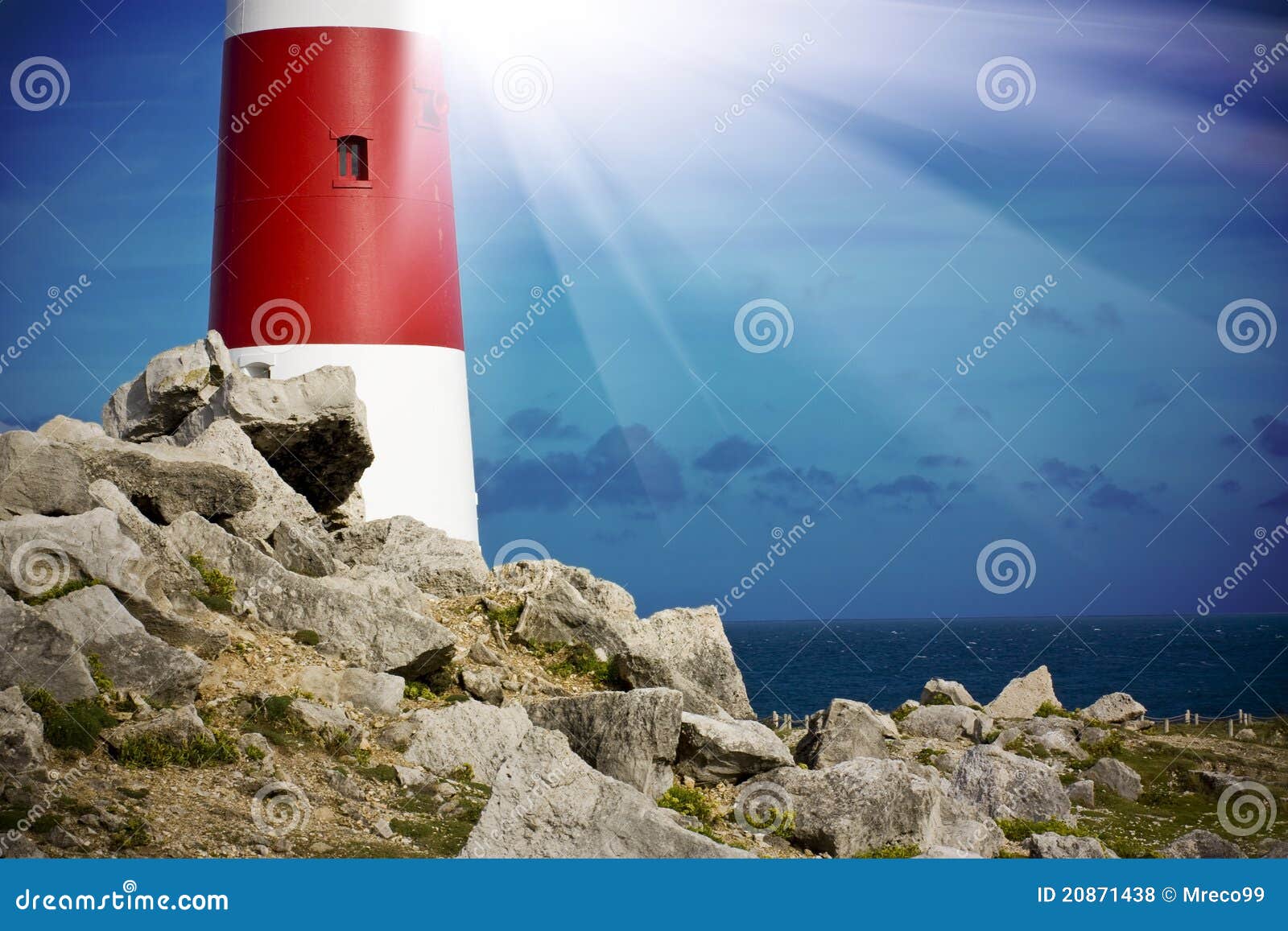 Lighthouse on Rocks with Light Beams Stock Photo - Image of dusk ...