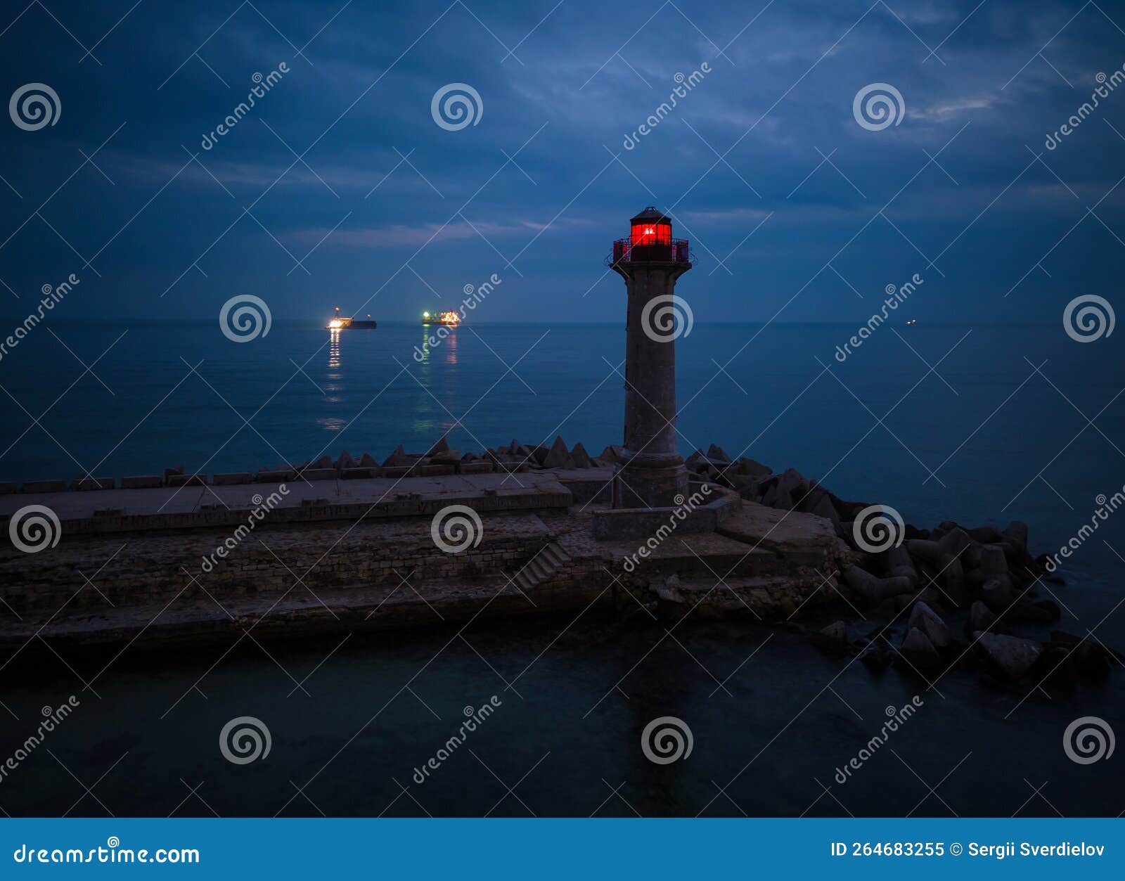 Lighthouse on the Seashore with Red Light at Night Against the ...