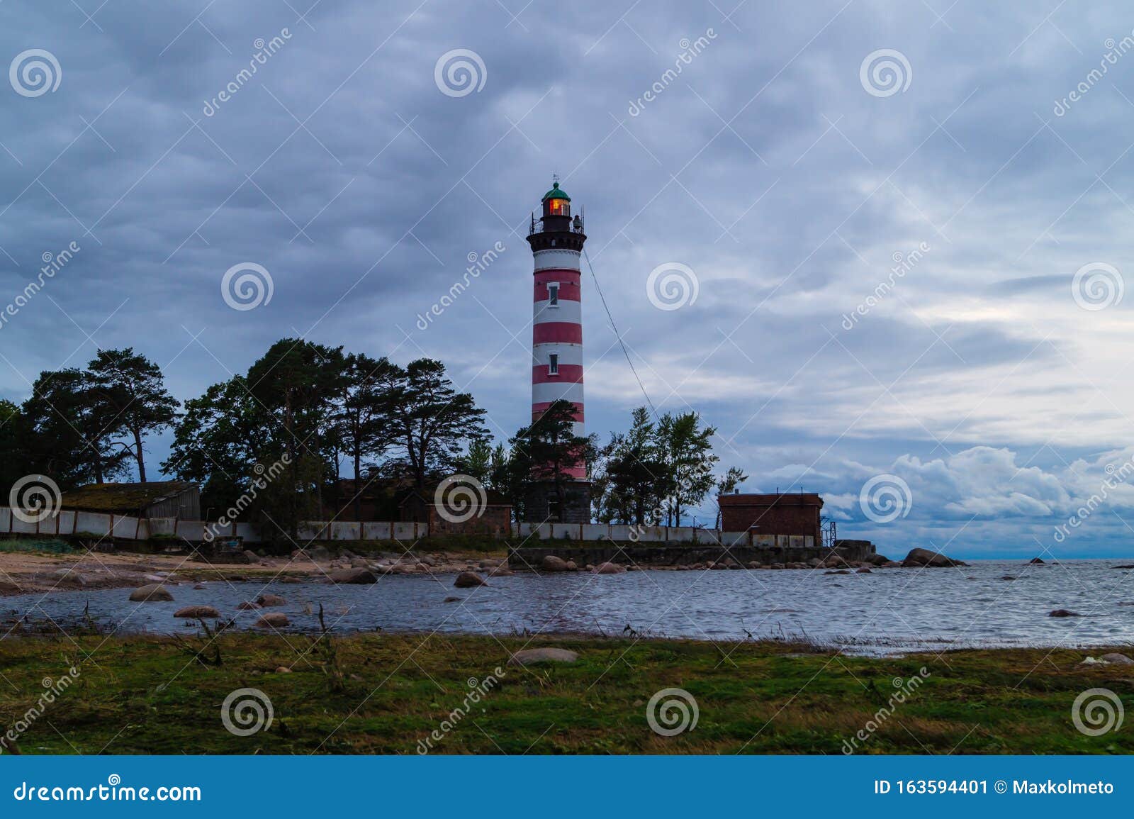 Lighthouse Shines Near the Shore at Sunset Stock Image - Image of ...