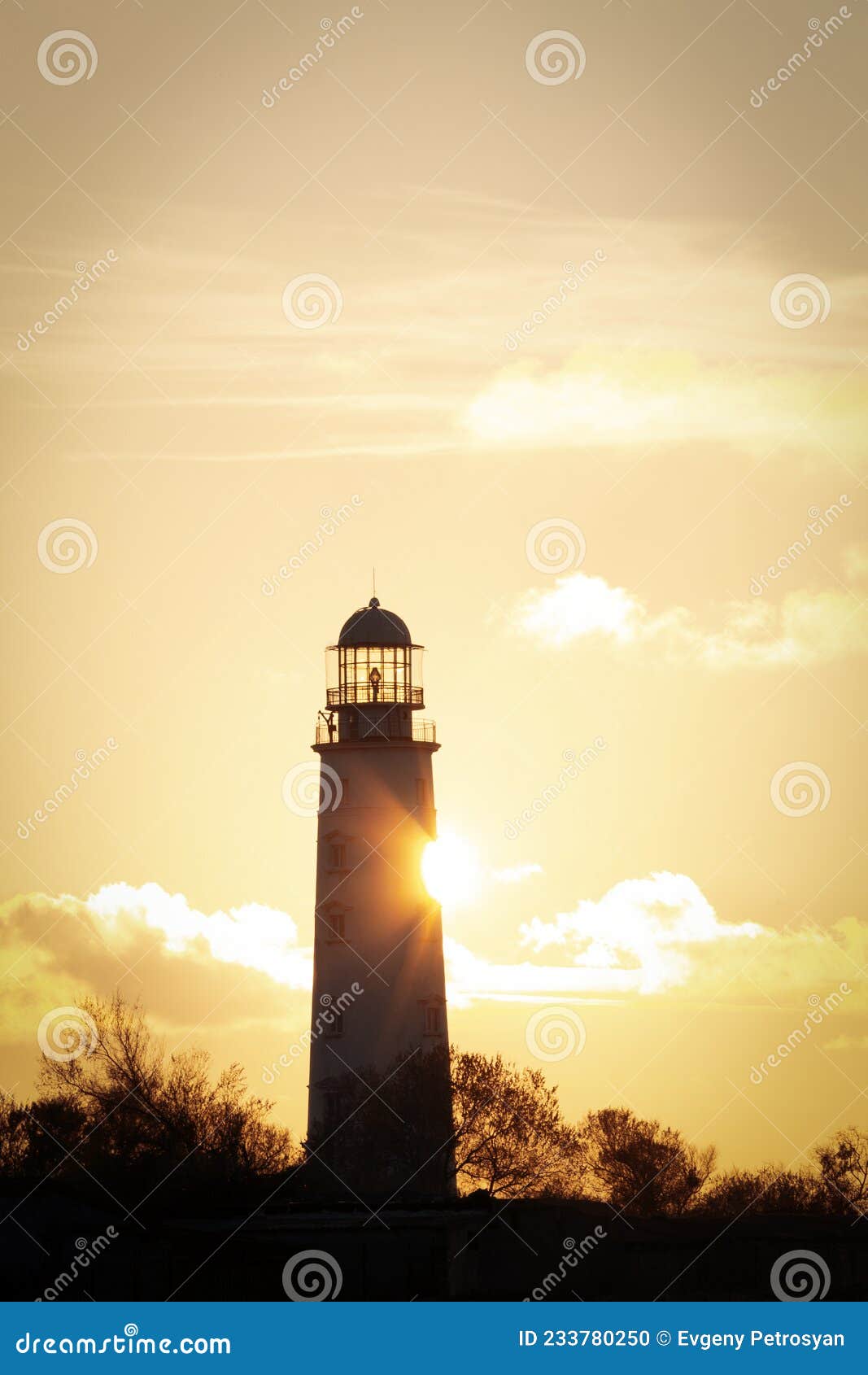 Lighthouse at Sunset through Which the Sun Shines through Stock Photo ...