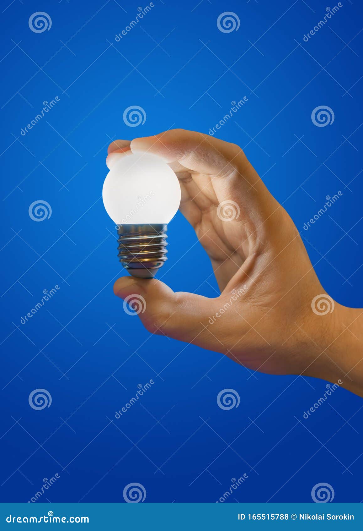 Lighting Lamp in Hand on Blue Stock Photo - Image of blue, electricity ...
