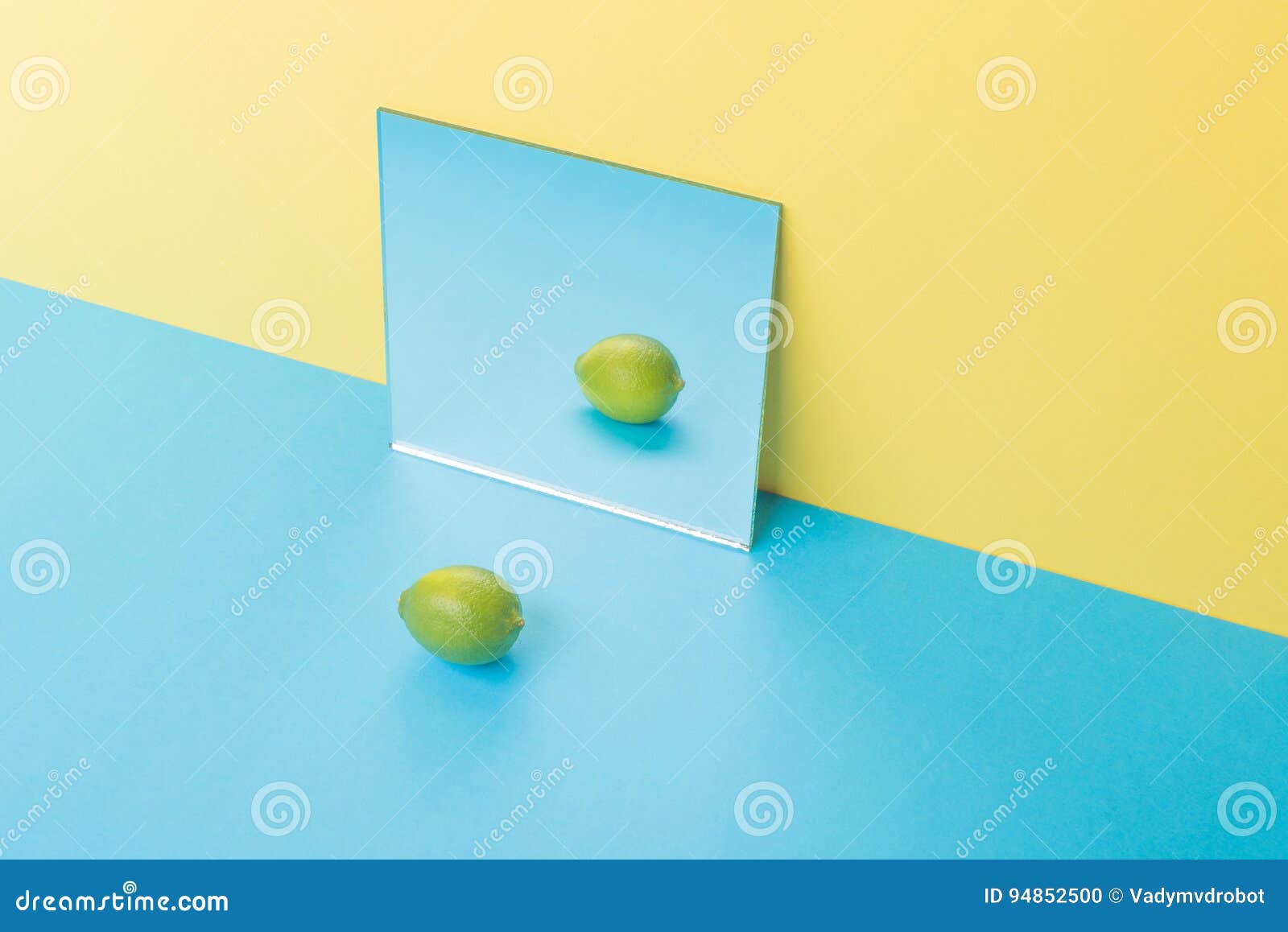 Lime on Blue Table Over Yellow Background Near Mirror Stock Photo ...