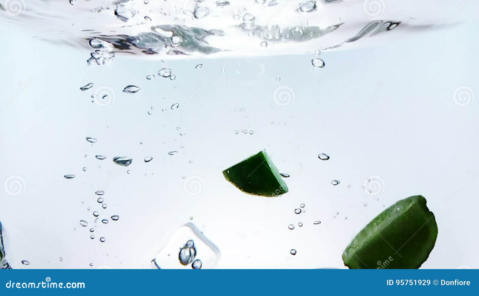 Lime Fruit and Ice Cubes Splash Falling Down into White Cocktail and ...