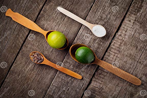 Lime on Spoons with Salt and Sugar Spoon on the Kitchen Table. Stock ...