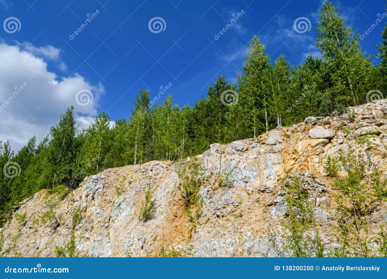 Limestone Cliffs Overgrown with Forest Against a Blue Summer Sky Stock ...