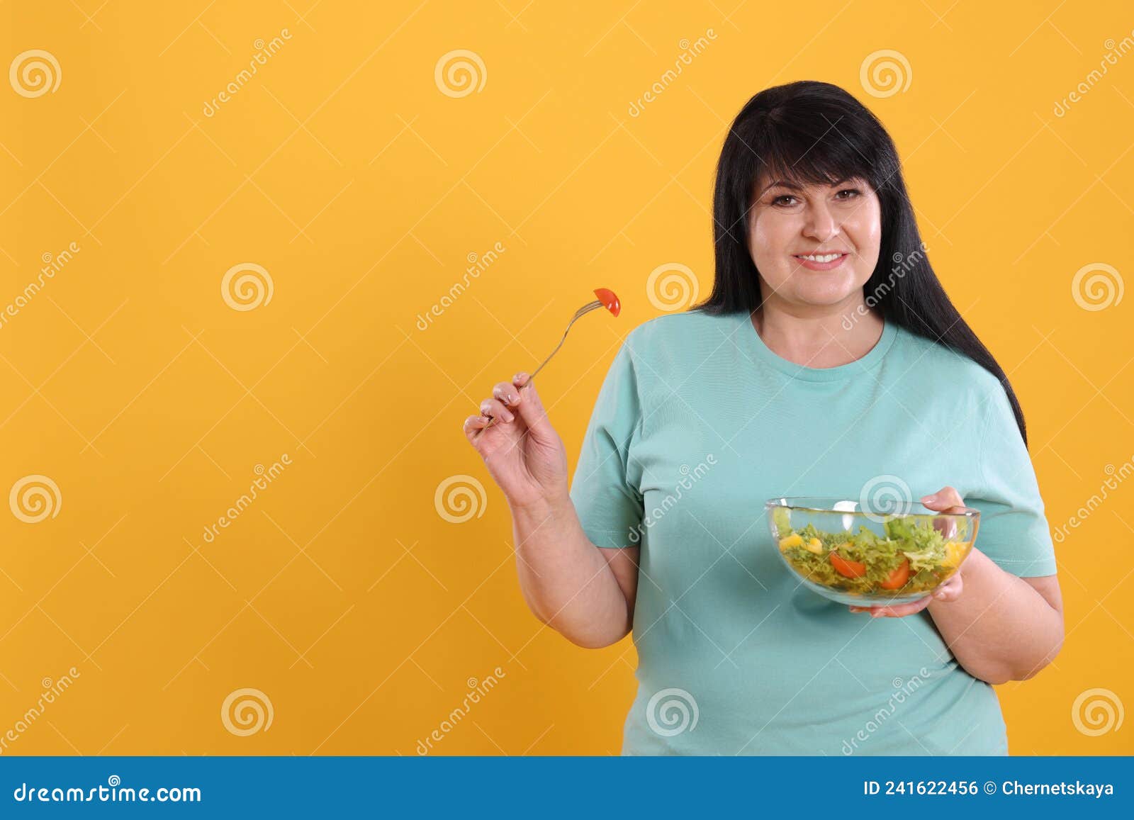 Linda Mulher Sobrepeso Comendo Salada Em Um Espaço Amarelo De Fundo ... Linda Mulher Sobrepeso Comendo Salada Em Um Espaço Amarelo De Fundo ...