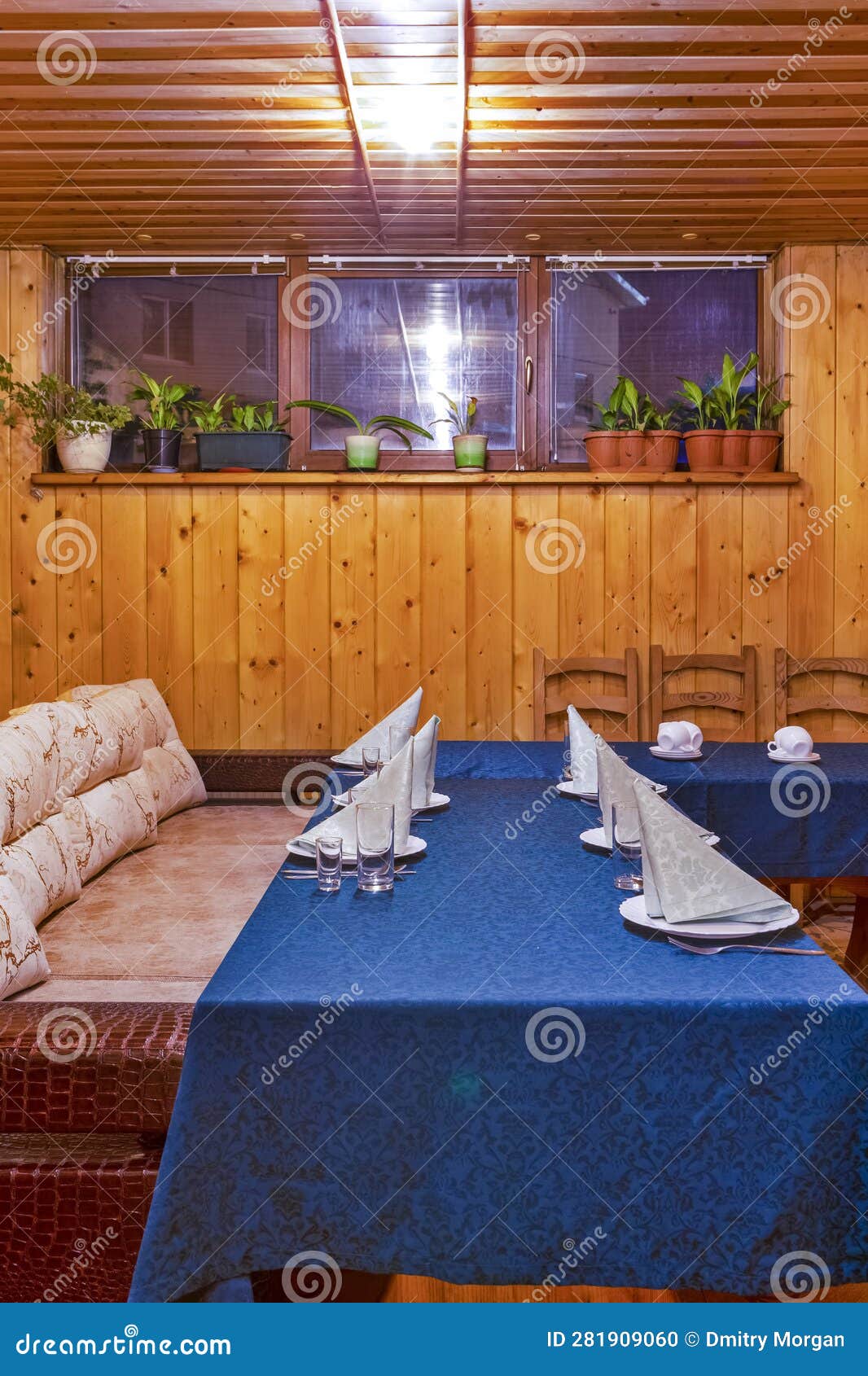 Line of Comfortable Couches with Dining Utensils on Tables Located ...