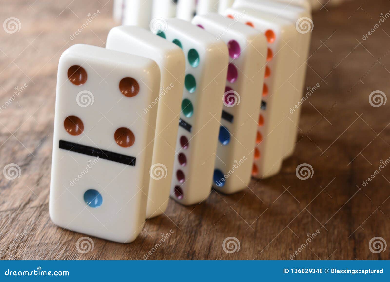 A line of dominoes on wood stock photo. Image of party - 136829348