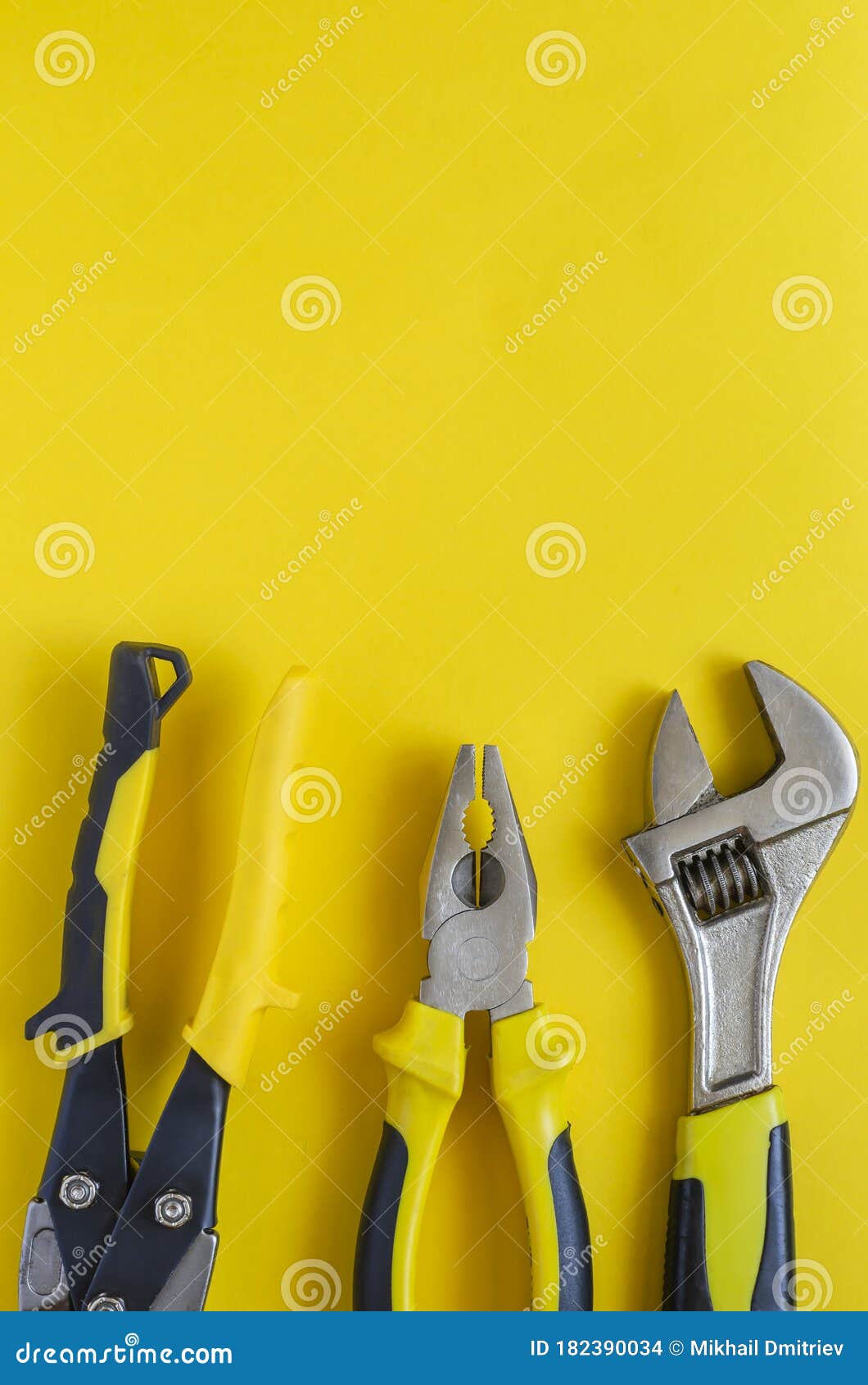 Line of Hand Tools with Black and Yellow Handles on a Yellow Background ...