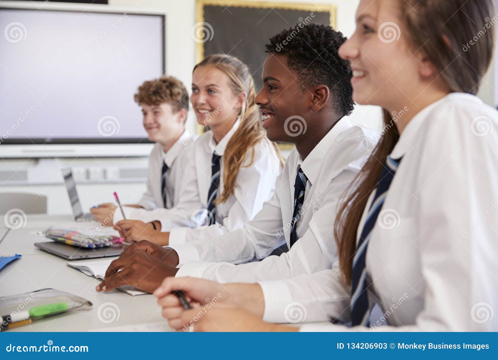 Line of High School Students Wearing Uniform Sitting at Desk in ...