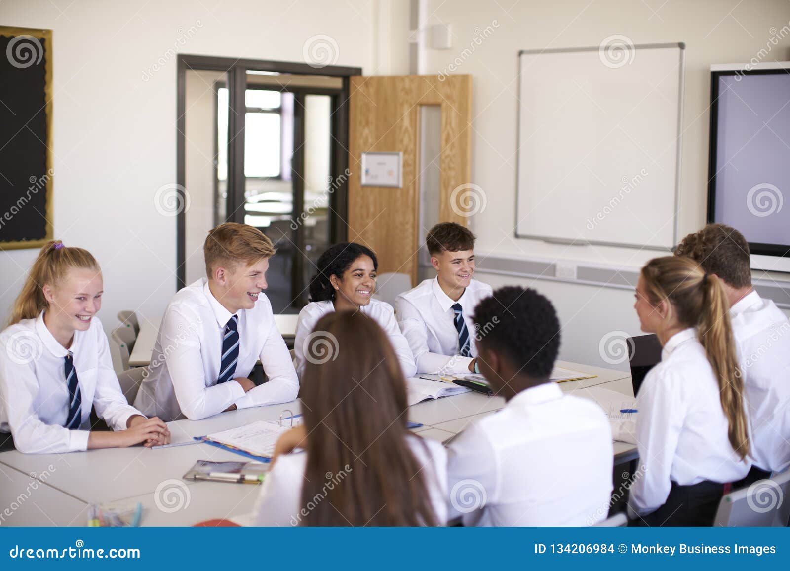 Line of High School Students Wearing Uniform Sitting at Desk in ...