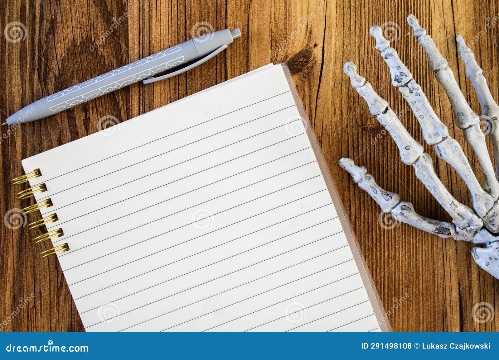 Lined Blank Note Pad Mock Up with Skeleton Hand and Gray Pen on Wooden ...