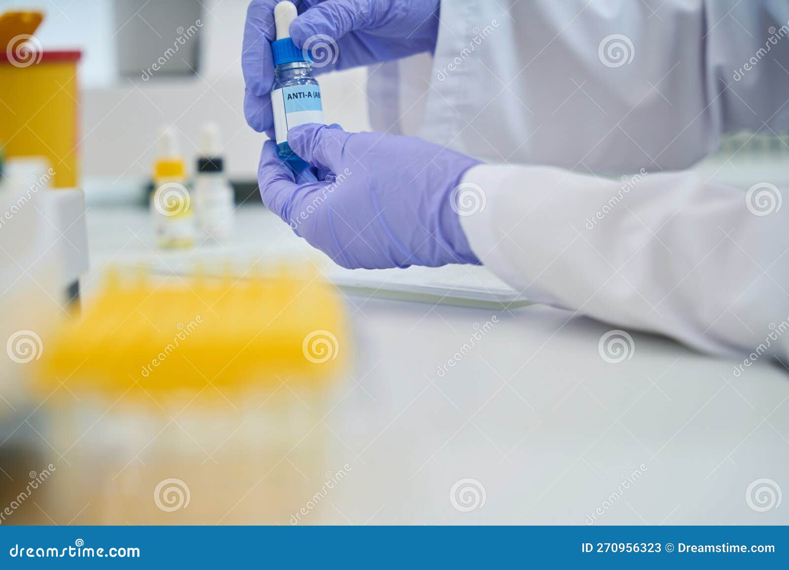 Liquid in a Bottle with a Blue Cap in the Hands of a Laboratory ...