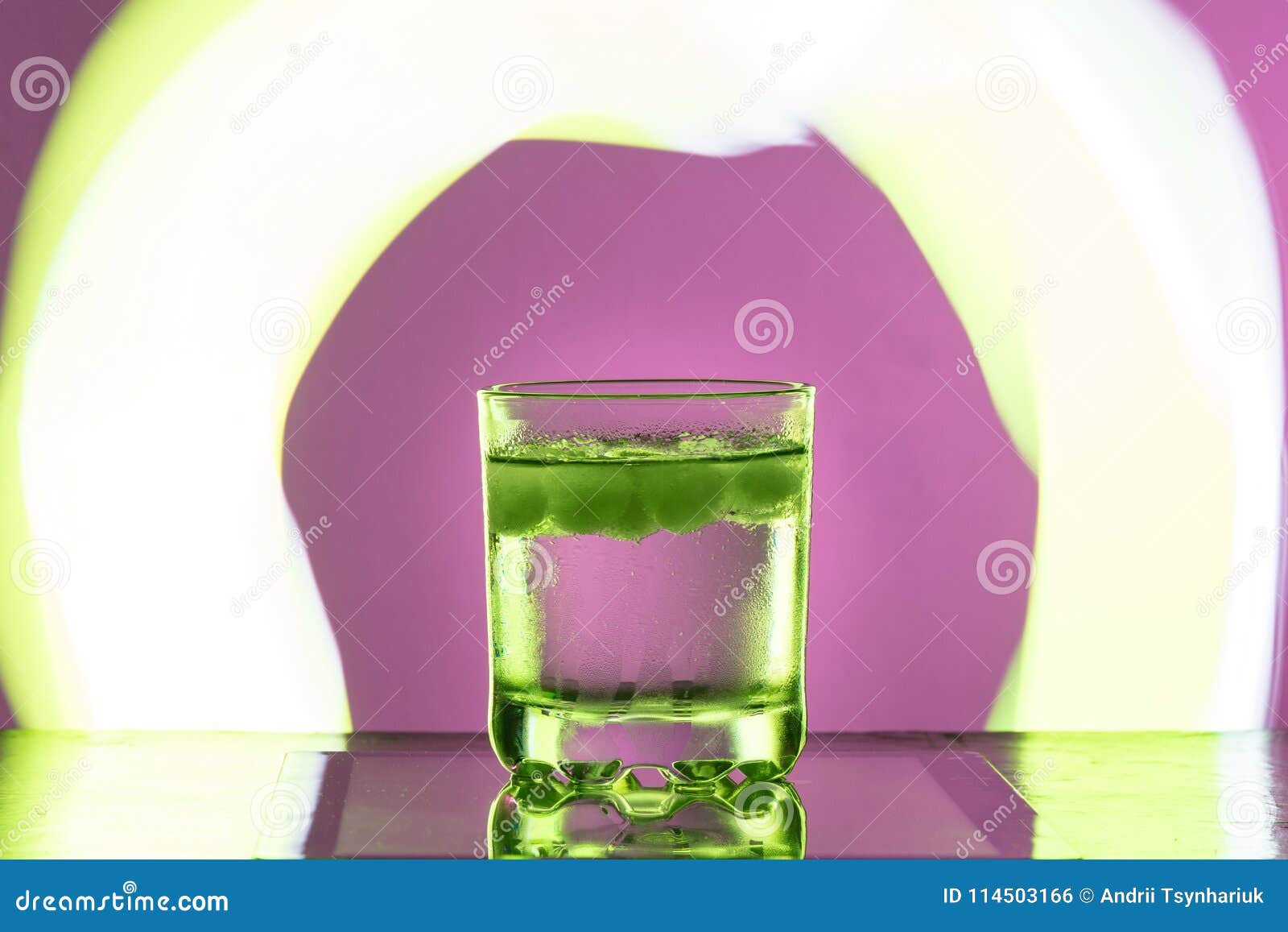 Liquid with Ice in a Glass on a Reflective Surface on a Reddish ...
