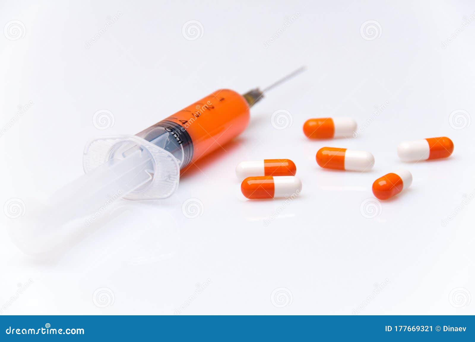 A Medical Syringe with a Orange Solution Lies on a White Background ...