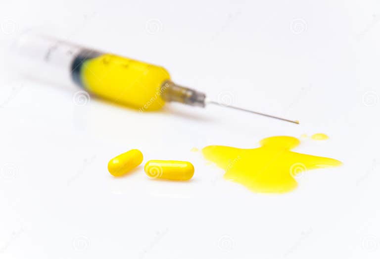 A Medical Syringe with a Yellow Solution Lies on a White Background ...