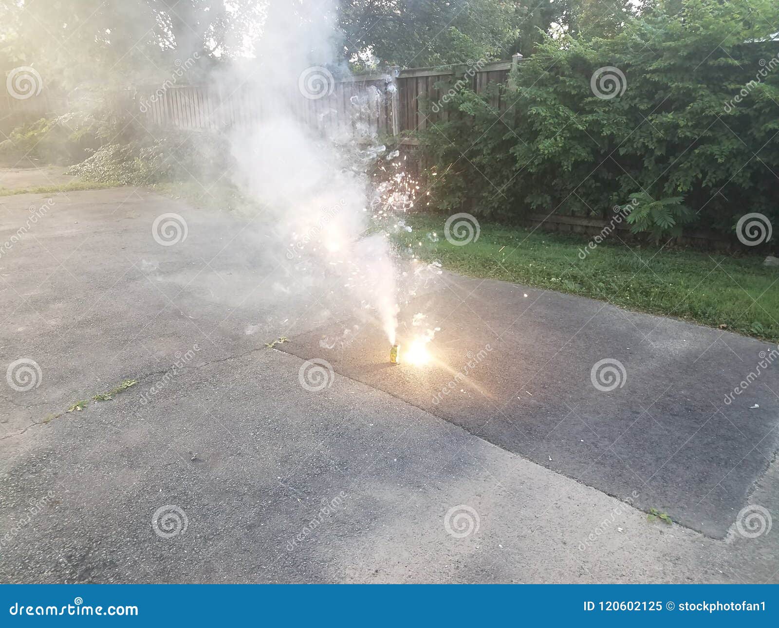 Lit Colorful Fireworks on Asphalt Driveway with Smoke Stock Image ...