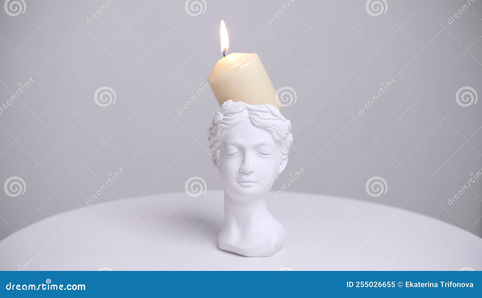 A Lit Candle in a Candlestick in the Shape of a Statue S Head Stock ...