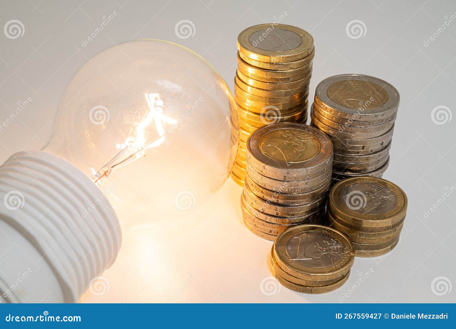 Lit Light Bulb with Coins beside it. Energy Tariffs Increase. Stock ...