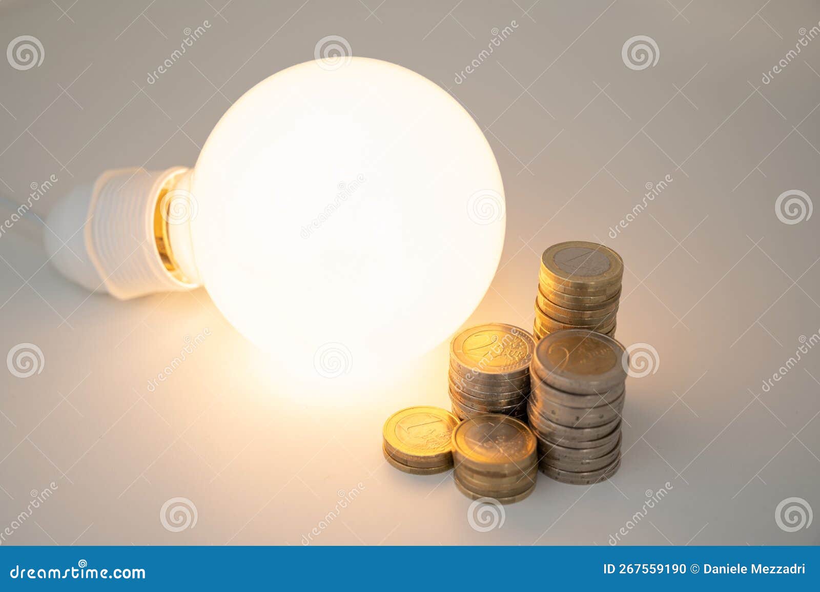 Lit Light Bulb with Coins beside it. Energy Tariffs Increase. Stock ...