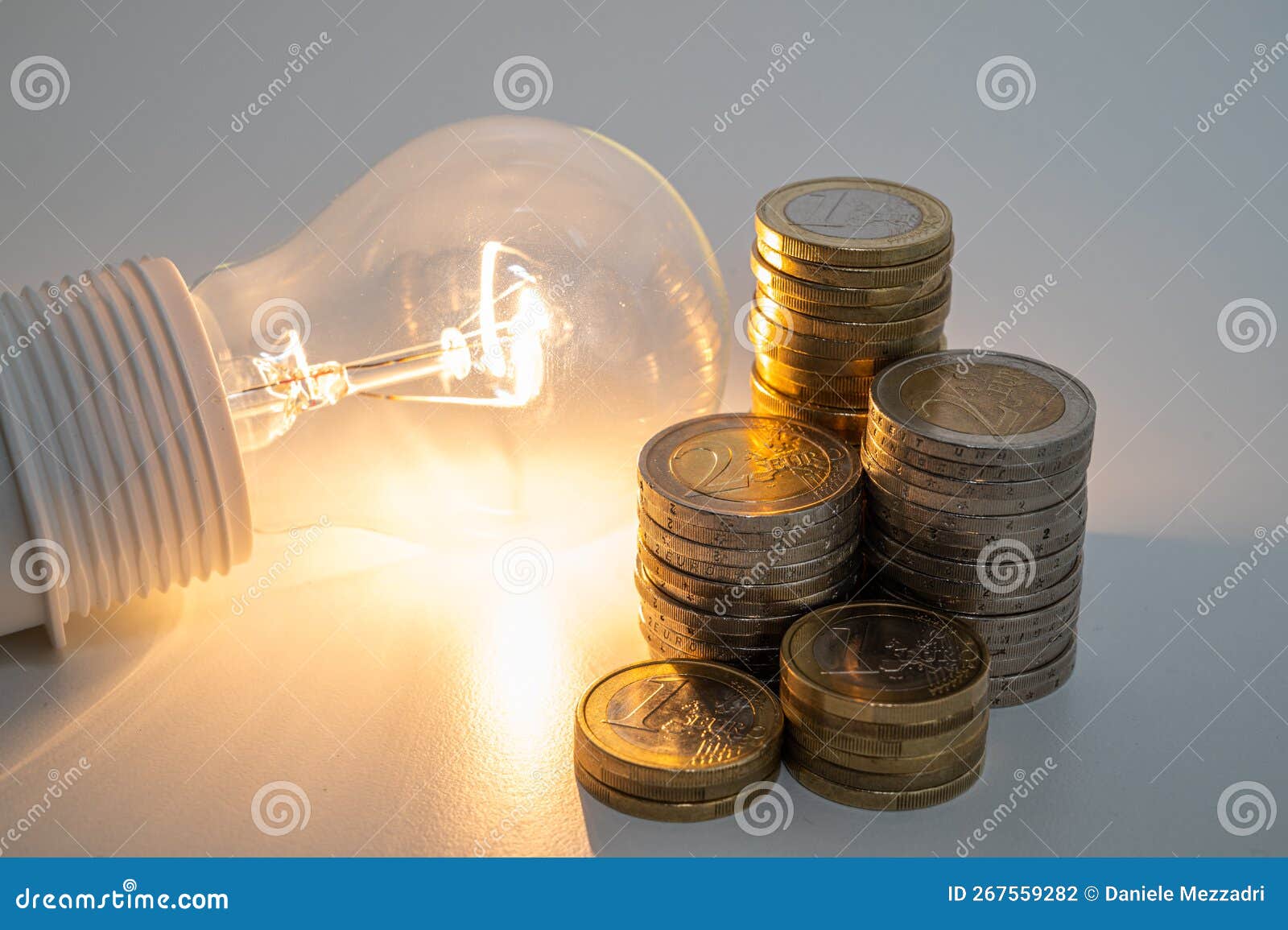 Lit Light Bulb with Coins beside it. Energy Tariffs Increase. Stock ...