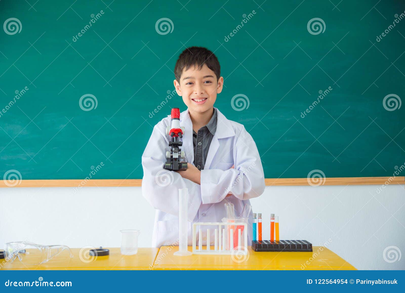 Boy Holding Microscope Smiling in Front of Classroom Stock Photo ...