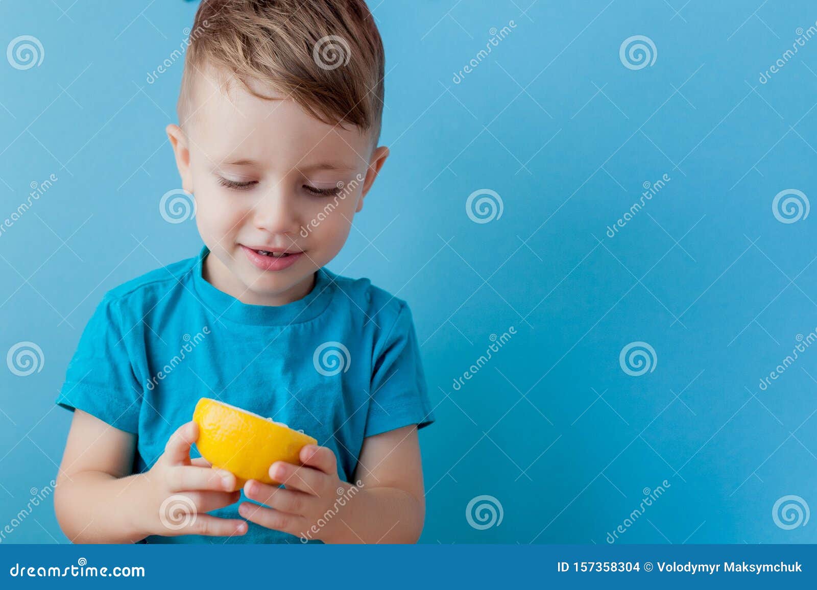 Little, Blond Boy Biting into a Lemon and Make a Face Stock Photo ...