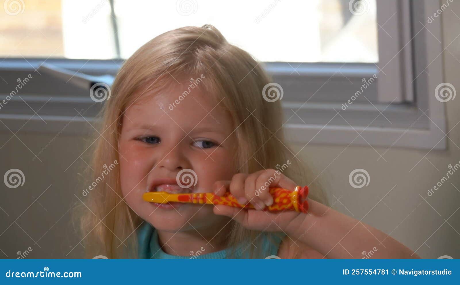 Little Blond Girl In Blue Shirt Is Brushing Her Teeth Carefully In The Bathroom Stock Video