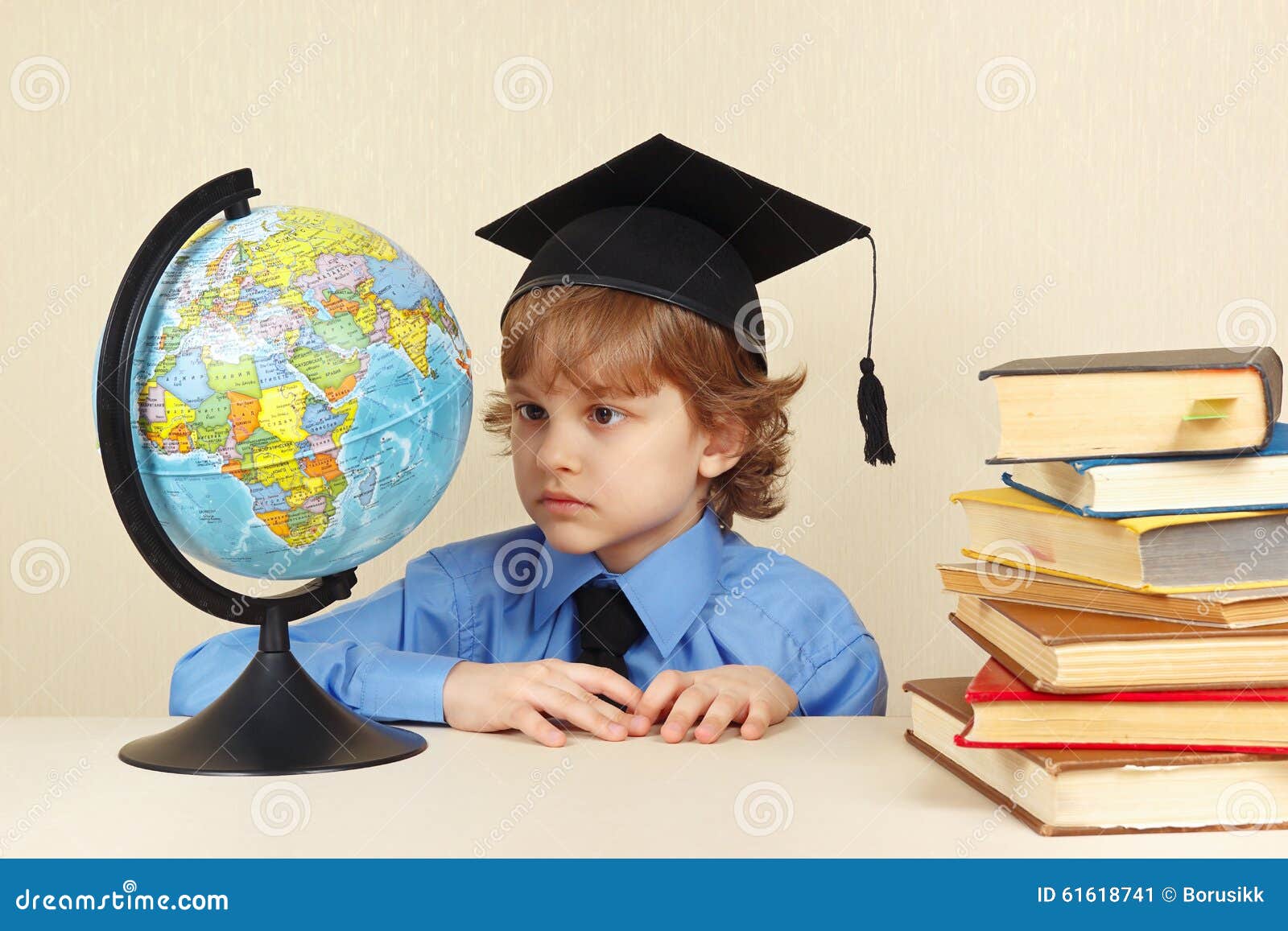 Little Boy in Academic Hat Looks at a Globe among Old Books Stock Image ...
